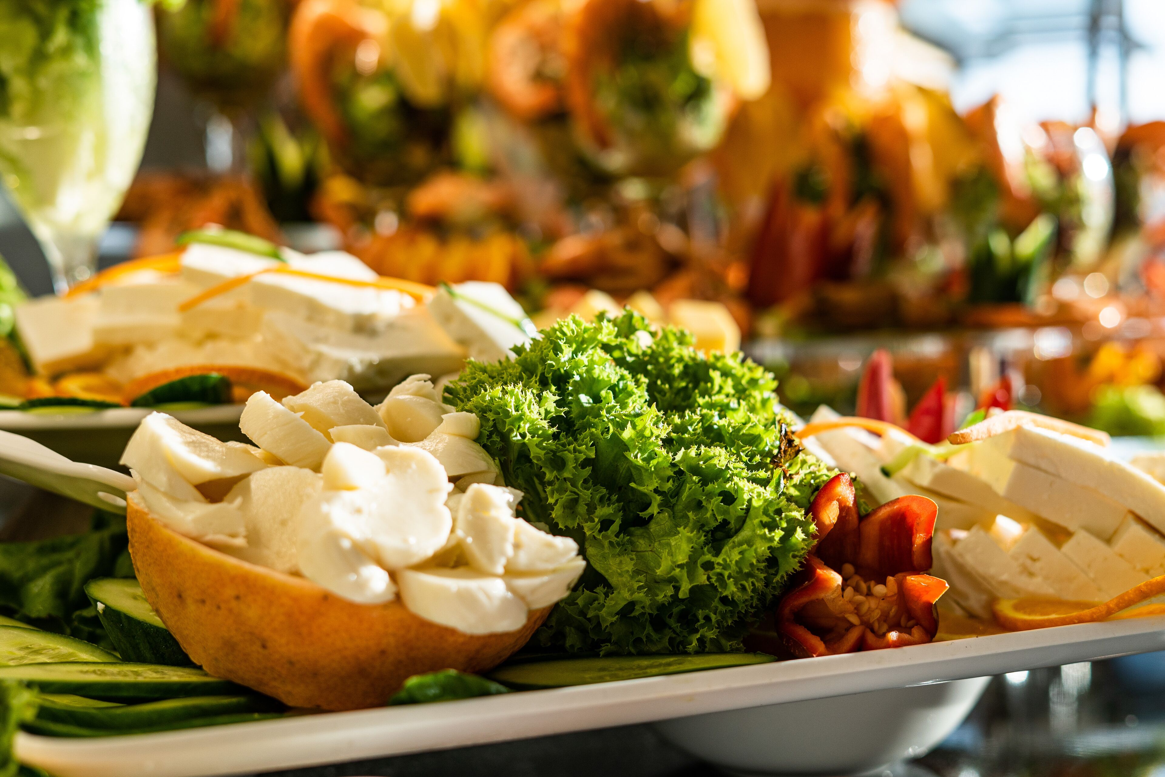 Diversos alimentos em uma bandeja, incluindo pão, alface e outros vegetais.