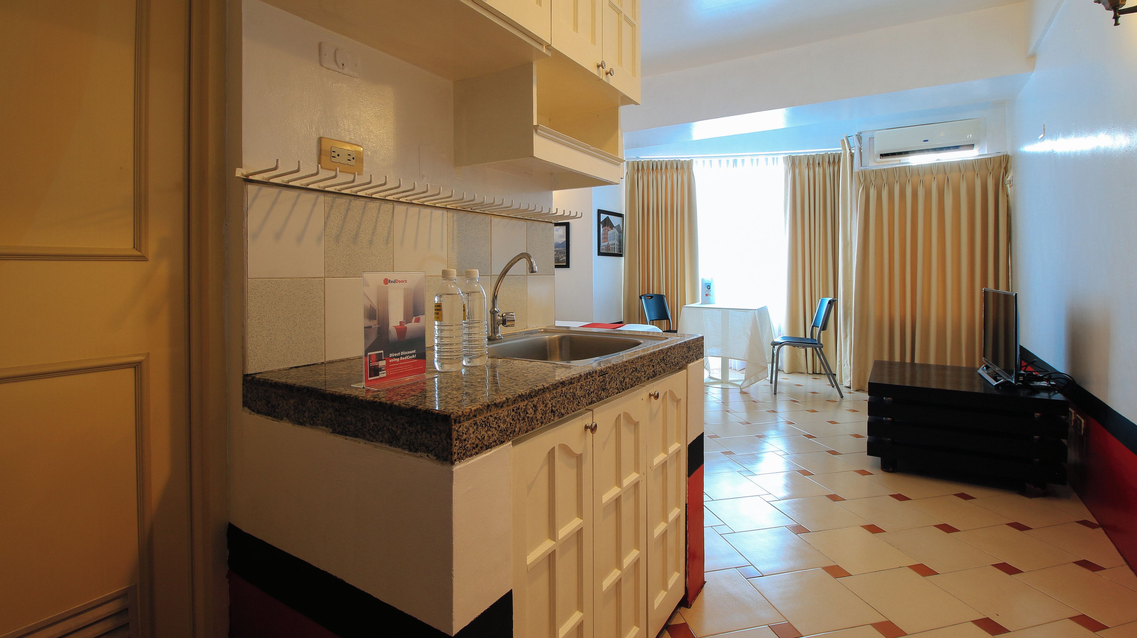 Uma cozinha com bancada de granito, pia e área de jantar com mesa e cadeiras.