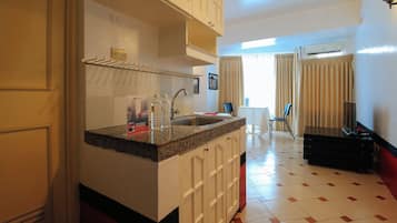 Uma cozinha com bancada de granito, pia e área de jantar com mesa e cadeiras.