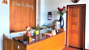 Uma mesa de recepção com tampo de vidro, painel de madeira e porta de madeira.