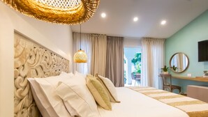 Quarto com uma cama grande, cabeceira com esculturas detalhadas, luminária pendente e vista do exterior pela janela.