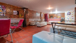 Decoração moderna com paredes de tijolo, assentos em branco e vermelho, e uma mesa de vidro.