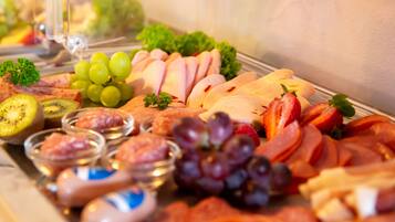Tábua de frios com diversos queijos, carnes, frutas e pequenos recipientes com patês.