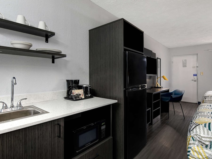 Um frigorífico/congelador grande, um micro-ondas, uma cafeteira/bule