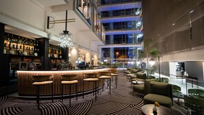 Uma área de bar moderna com balcão curvo, vários bancos e piso estampado.