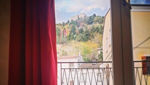 Quarto com vista para uma colina e um edifício.