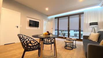 Apartamento premium, 1 quarto, sacada, vista para o jardim | Área de estar | TV LED 32 polegadas com canais a cabo, TV