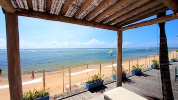 Um deck de madeira com vista para uma praia e o oceano.