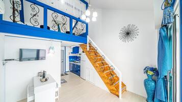 Um apartamento moderno com cozinha, área de refeições, sala de estar e escada.