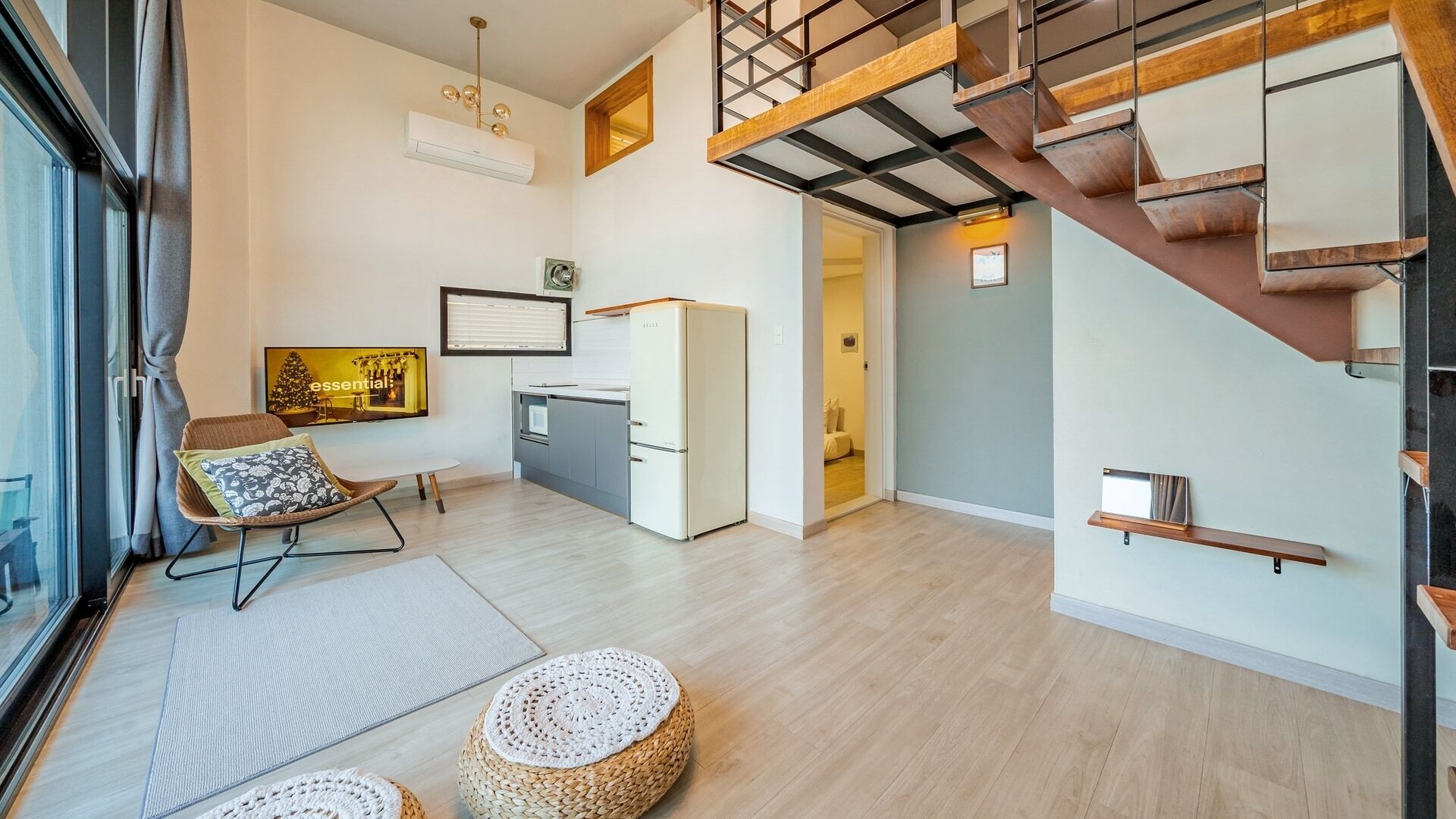 Um apartamento moderno com cozinha, área de refeições e escada.