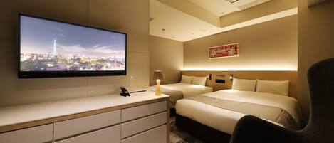 Quarto de hotel com cama, escrivaninha, televisão e cadeira.