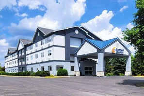 Um hotel de vários andares com telhado azul e uma placa que diz 'Comfort Suites'.