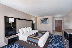 Quarto de hotel com cama, televisão de tela plana, escrivaninha e porta.