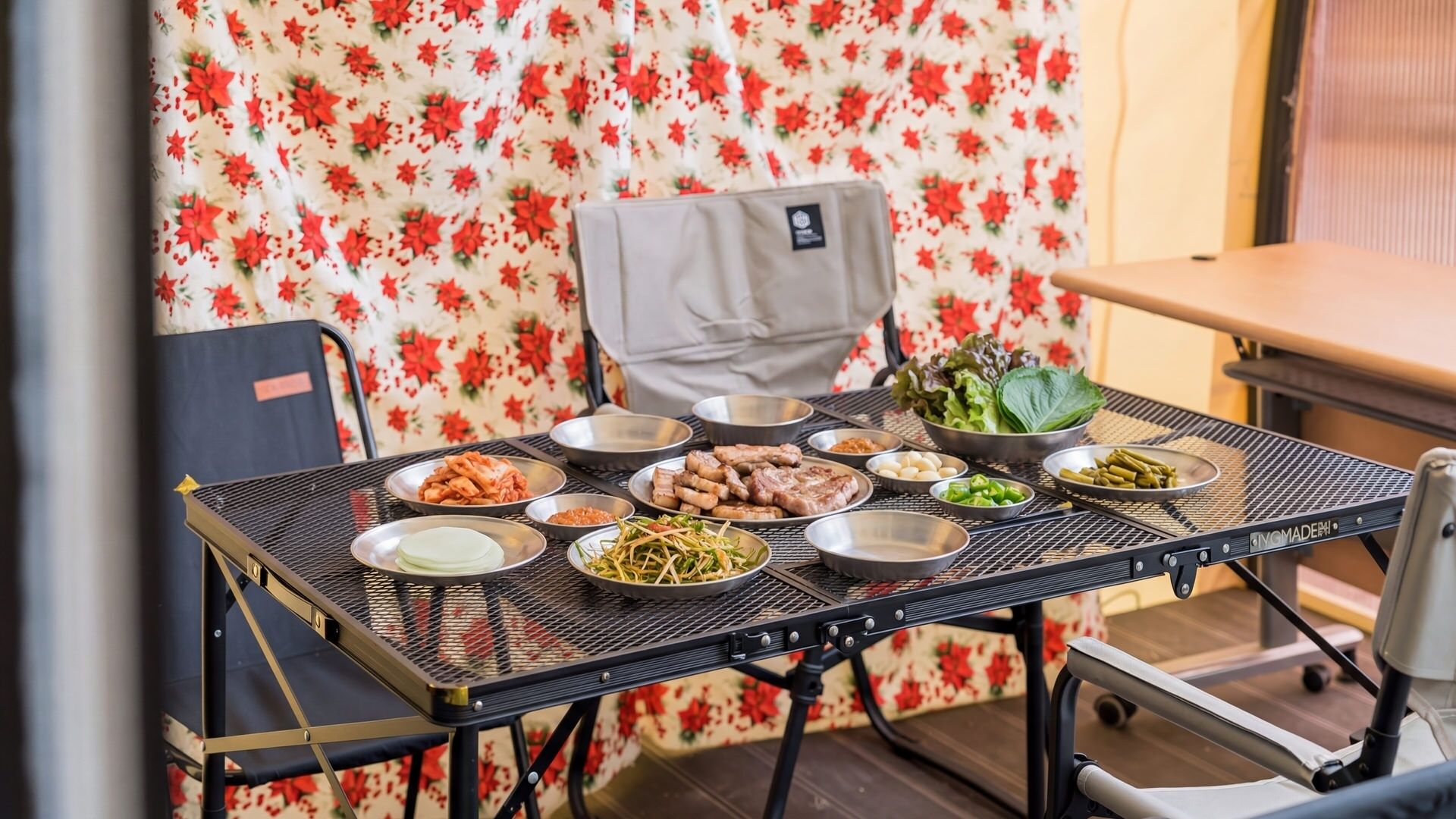 Uma mesa posta com diversos pratos, uma cadeira e um painel decorativo.