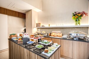 Uma mesa de buffet com diversos alimentos e bebidas.