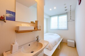 Uma casa de banho moderna com lavatório, espelho e mesa de cabeceira.
