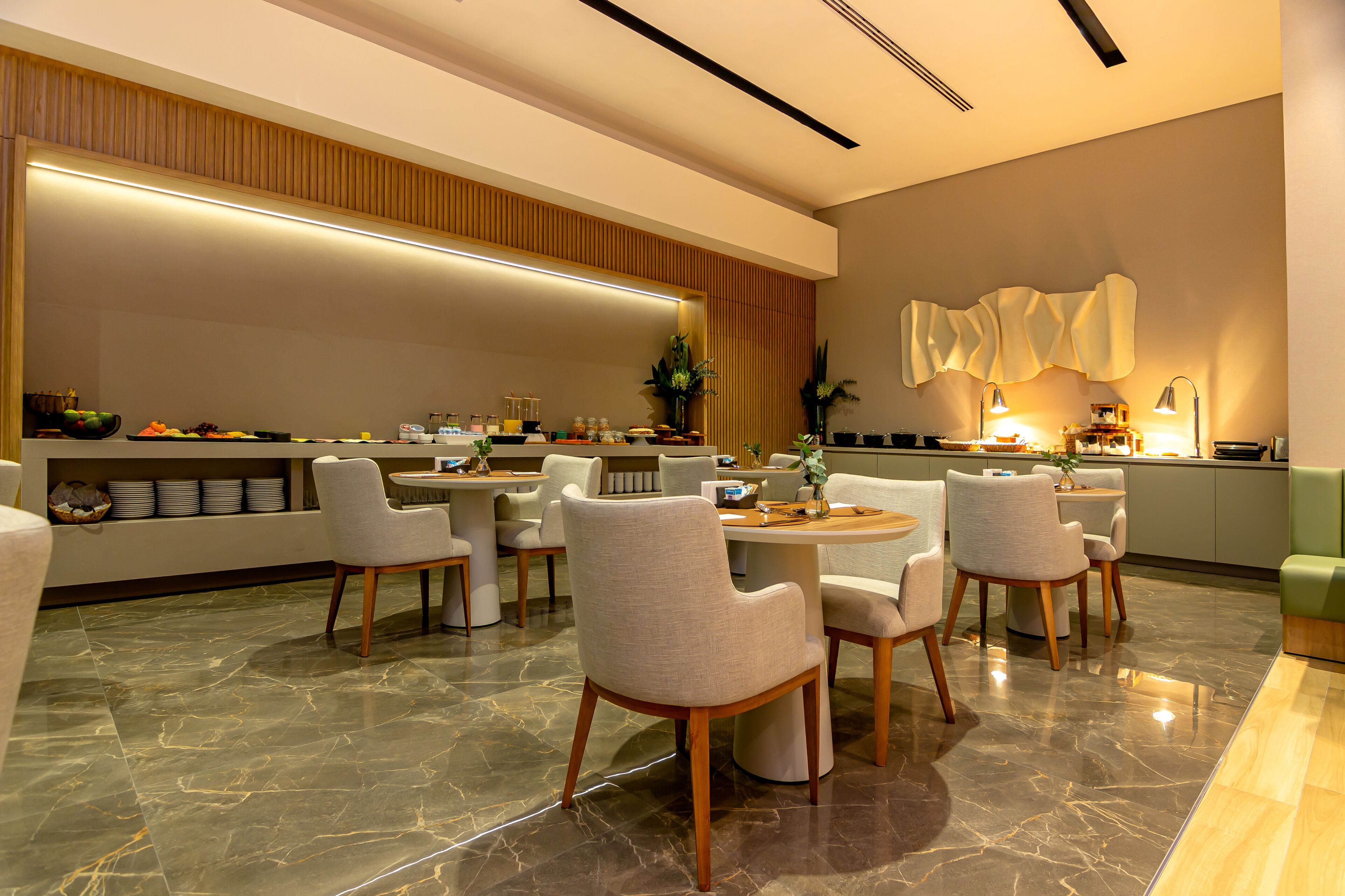 Uma sala de jantar moderna com piso de mármore, móveis contemporâneos e um serviço de buffet.