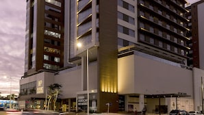 Um hotel moderno com vários andares e uma entrada imponente.