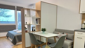 Um espaço compacto com cama, cozinha compacta, área de refeições e sala de estar.