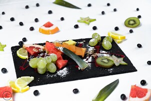 Prato de sobremesa com diversas frutas e um enfeite em formato de estrela.