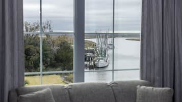Vista da janela sobre uma marina com barcos e uma área gramada.