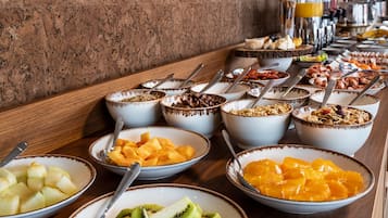 Buffet com diversas opções de alimentos, incluindo frutas e cereais.