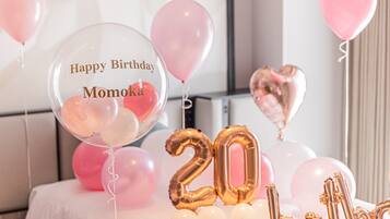 Decoração de festa de aniversário com balões e um cartaz escrito 'Feliz Aniversário Momoka'.