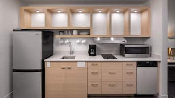 Um frigorífico/congelador grande, um micro-ondas, uma placa de cozinha