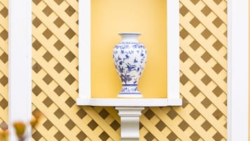 Uma janela com moldura branca e um vaso azul e branco.