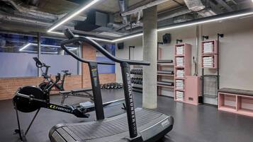 Uma academia com equipamentos de cardio, pesos e prateleiras bem organizadas.