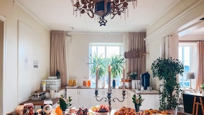 Uma sala de jantar com mesa de madeira, velas e diversos alimentos.