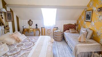 Quarto com duas camas, uma mesa de toucador e uma janela.