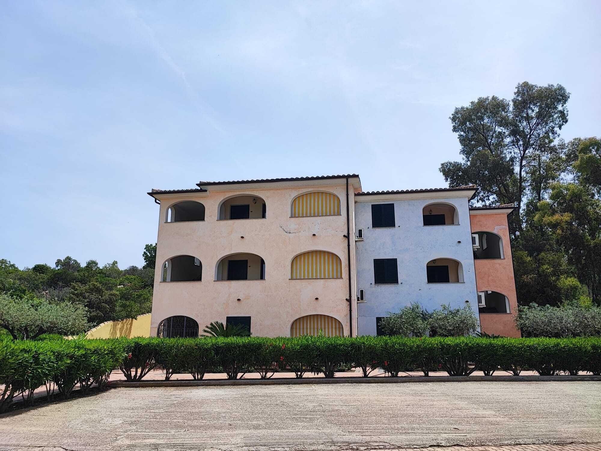 Um edifício com várias andares e fachada simétrica, com janelas em arco e uma entrada central.