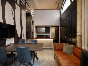 Um interior moderno com área de refeições, cozinha e espaço para sentar.
