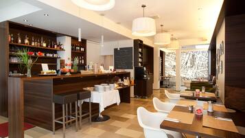 Um restaurante moderno com área de bar, cadeiras brancas e chão xadrez.