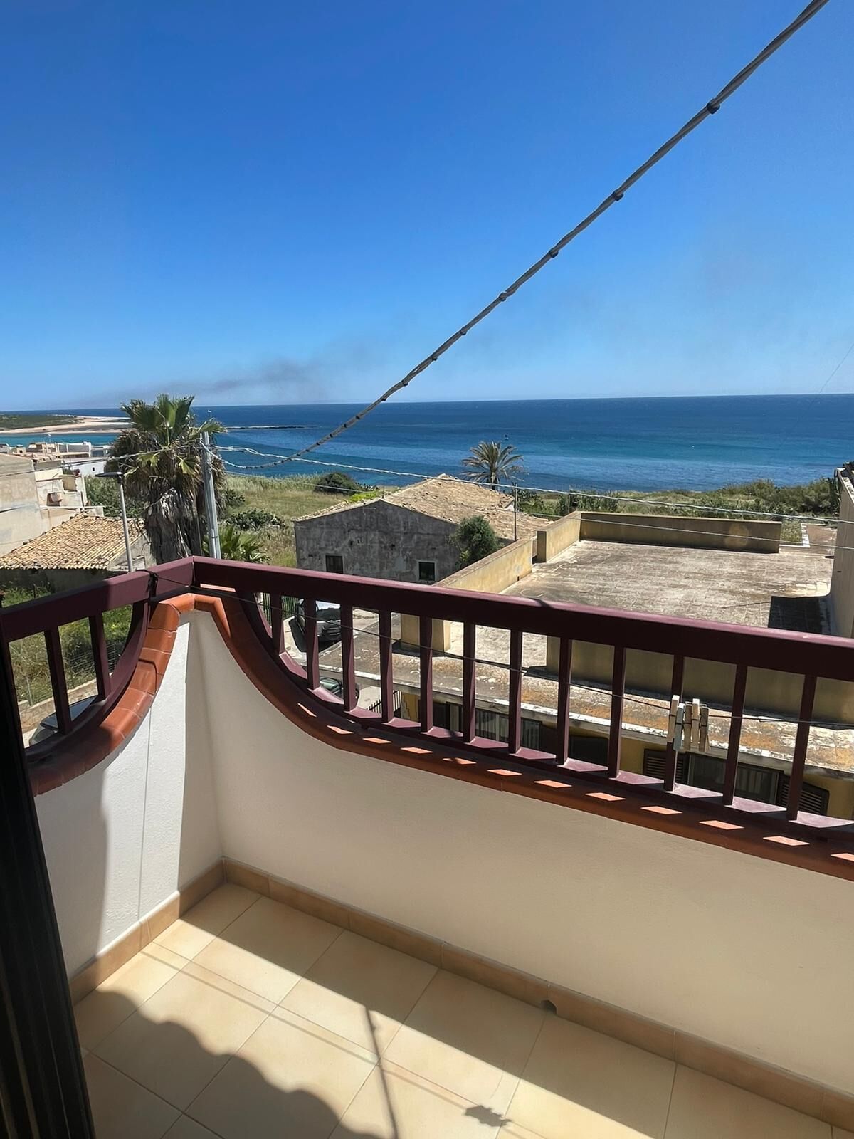 Uma varanda com vista para o mar e edifícios.