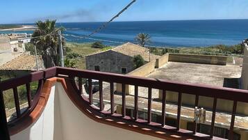 Uma varanda com vista para o mar e edifícios.
