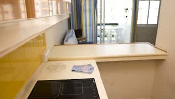 Um frigorífico, uma placa de cozinha, uma cafeteira/bule