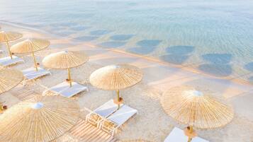 Praia particular, espreguiçadeiras, guarda-sóis, toalhas de praia