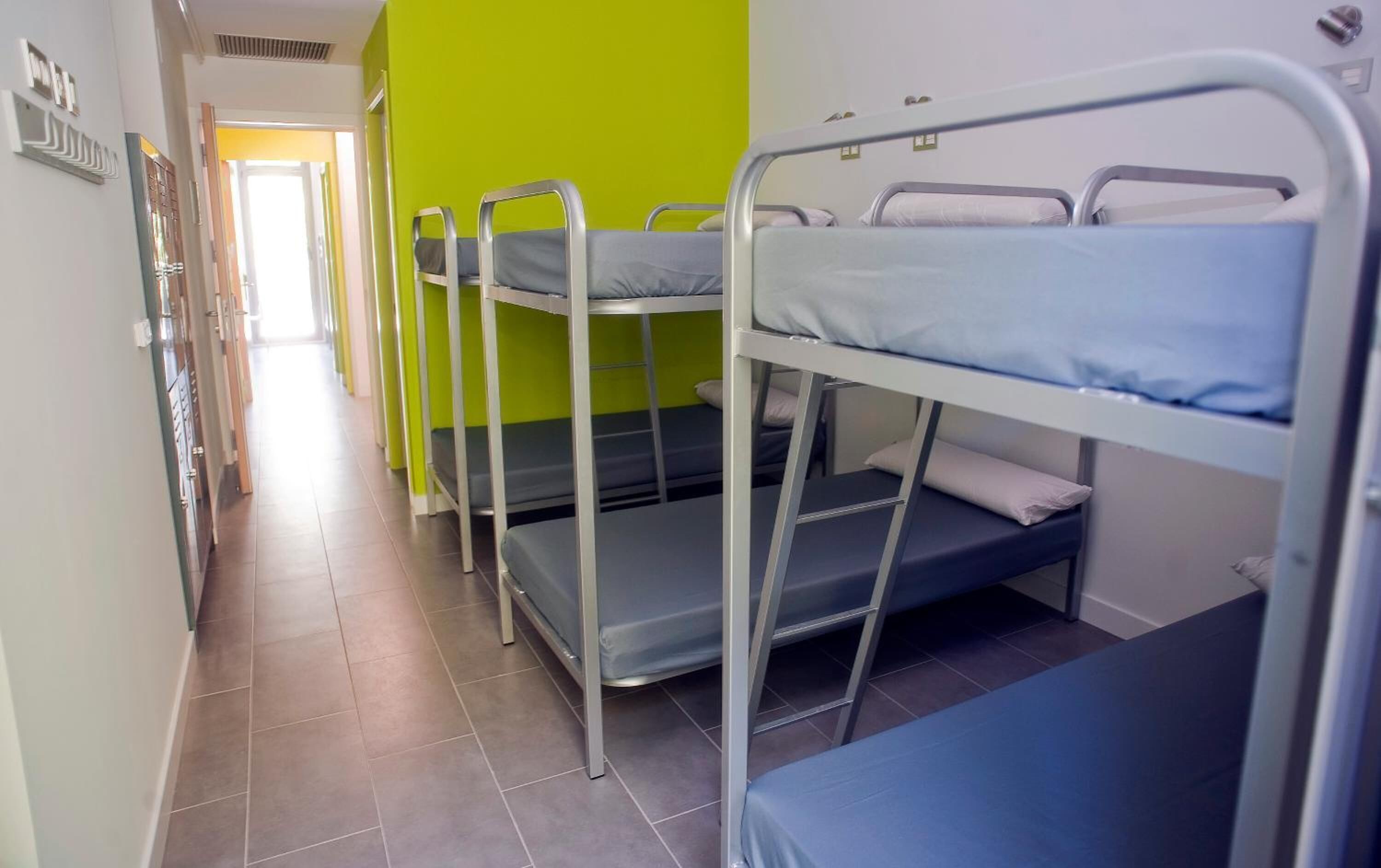 Corredor com beliches em um hostel ou dormitório.