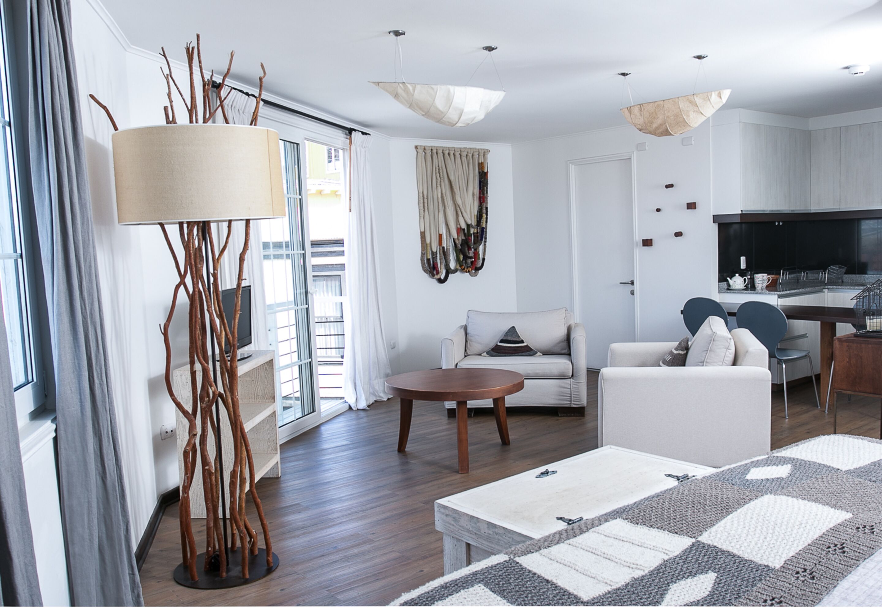 Uma sala de estar moderna com um sofá, mesa de centro e galhos decorativos.