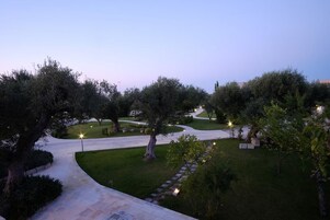 Um jardim bem cuidado com caminhos, árvores e iluminação.