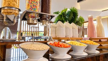 Disposição de buffet com diversos alimentos e uma máquina de café.
