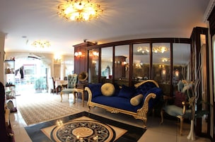 Uma sala de estar luxuosa com um sofá azul, mobiliário requintado e um candelabro.