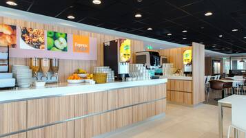 Um café moderno com balcão de madeira, diversos displays de comida e áreas de estar.