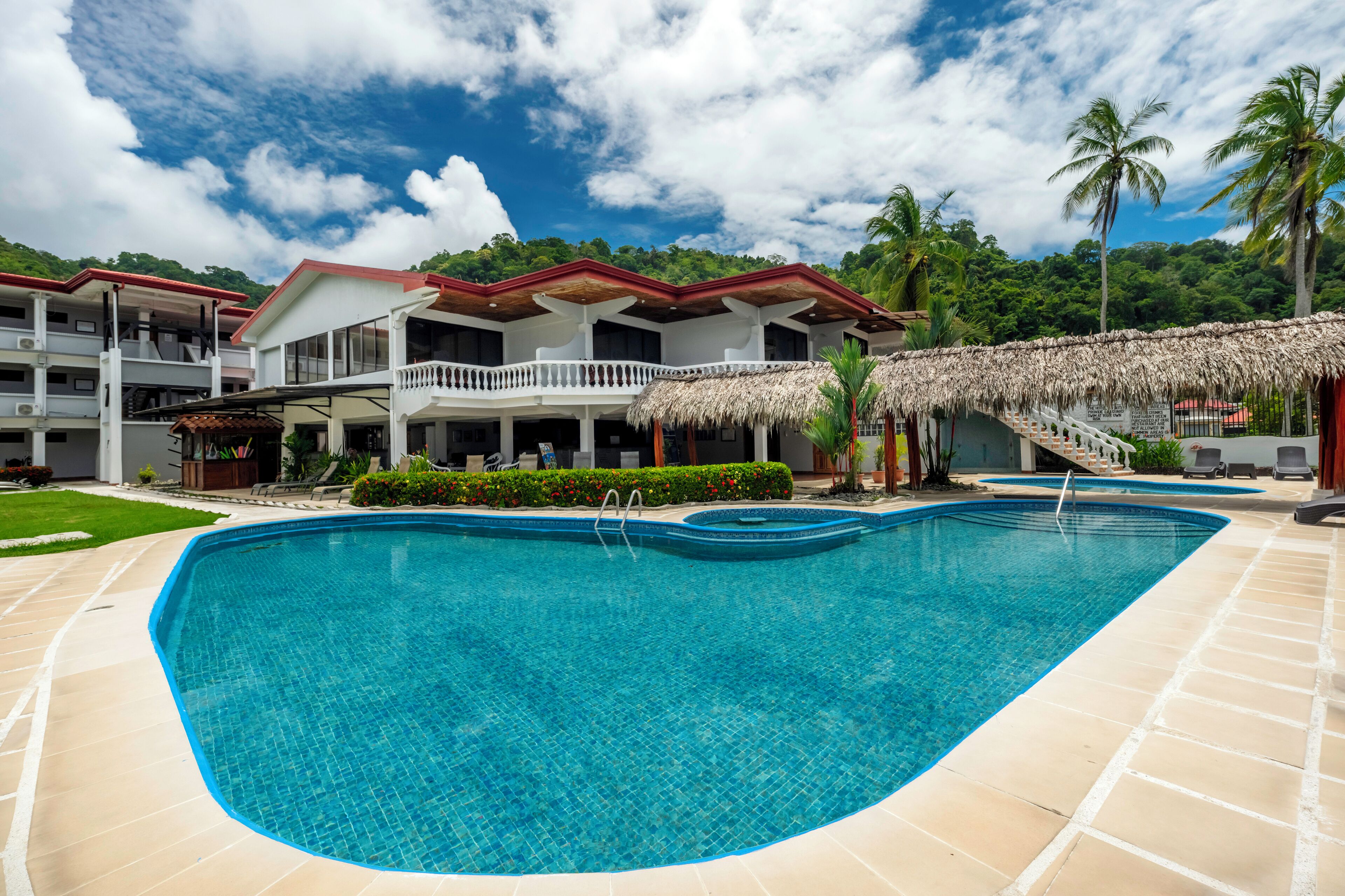 Uma área de piscina com um edifício ao fundo.