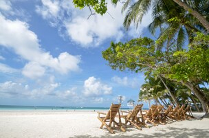 Perto da praia, praia de areia branca, espreguiçadeiras 