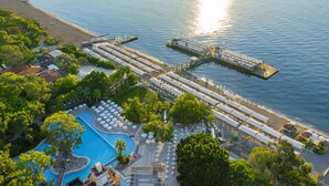 Vista aérea de um resort com piscina, praia e cais.