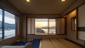 Um quarto japonês tradicional com tatames, uma mesa baixa e portas deslizantes.