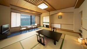 Um quarto japonês tradicional com tatames, uma mesa baixa e portas deslizantes.